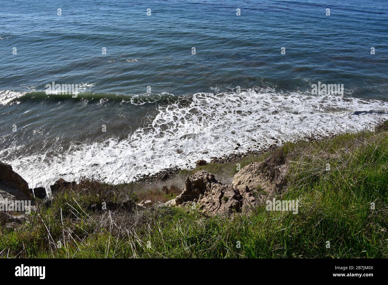 A view down the bluffs at the waves along the Pacific Ocean Stock Photo ...