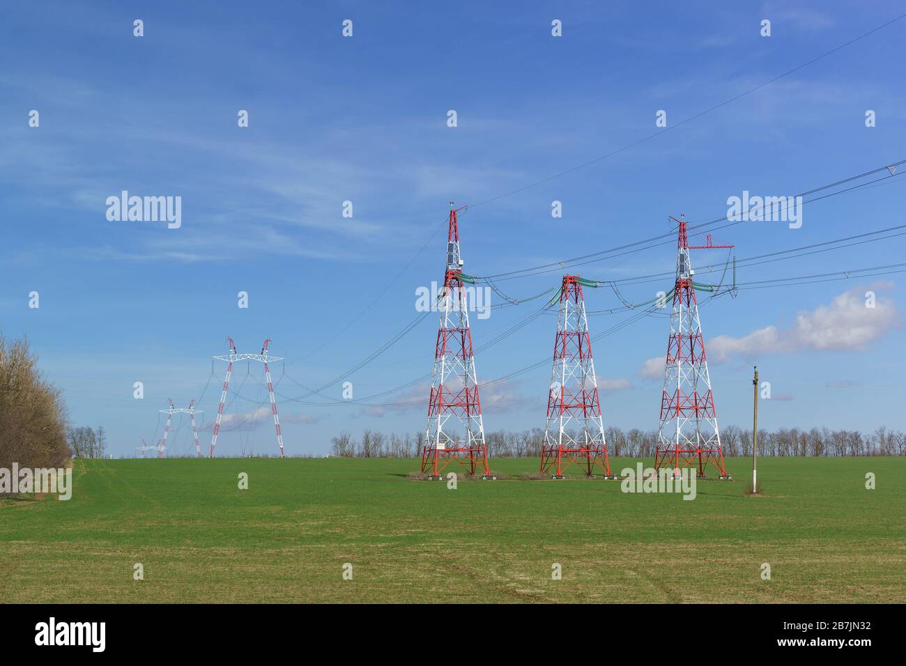 Supports power lines are in the field. Red and white against the blue ...
