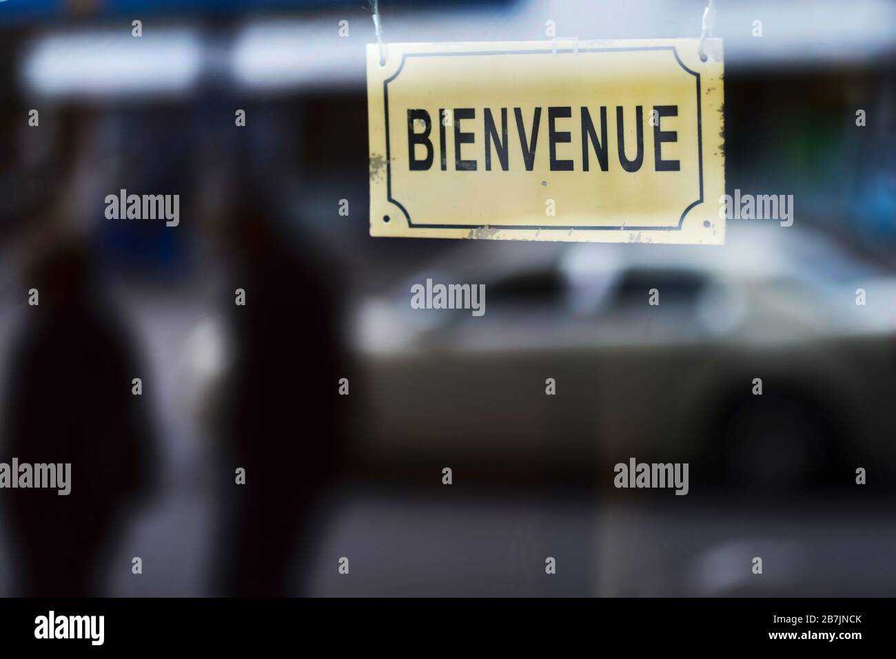 closeup of an old signboard with the text bienvenue, open welcome ...
