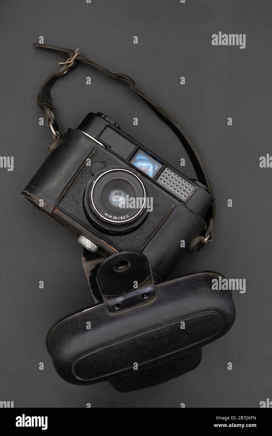 Closeup of an old 60s camera with its leather case on gray background ...