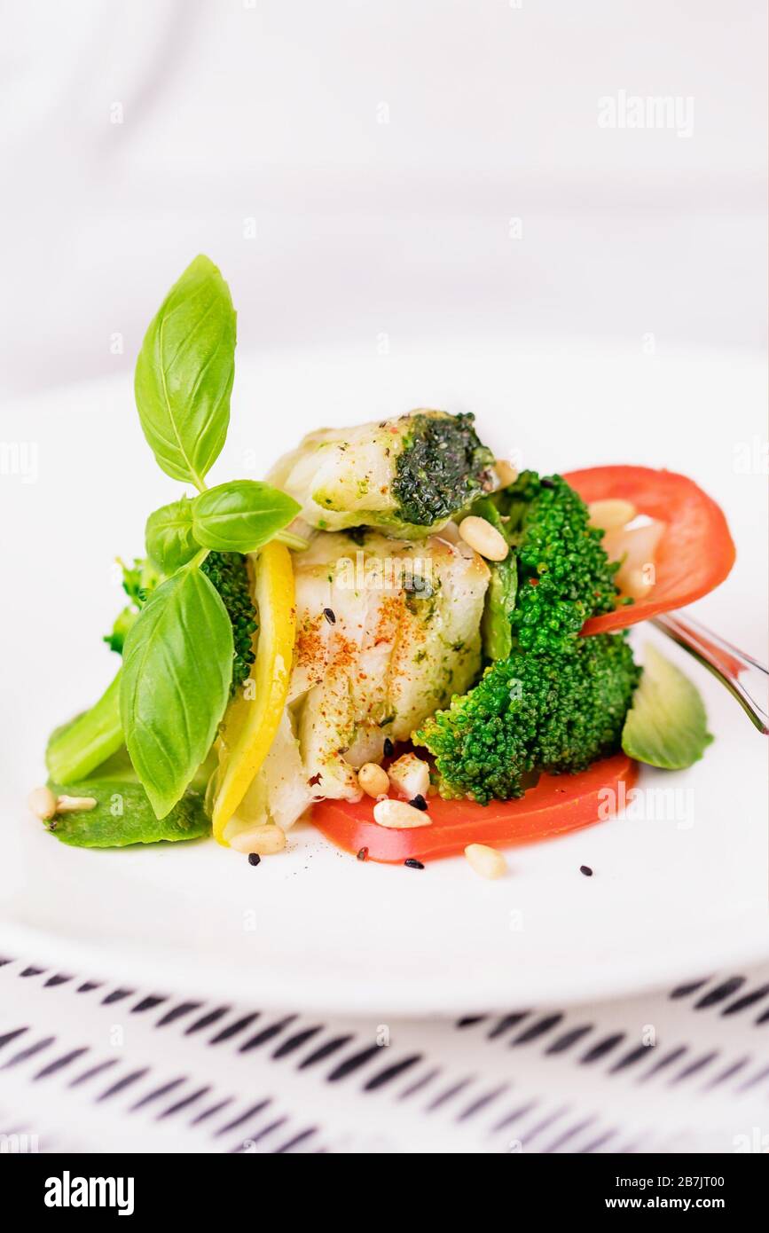 Steamed cod fish fillet with broccoli, tomato, lemon, avocado, basil ...