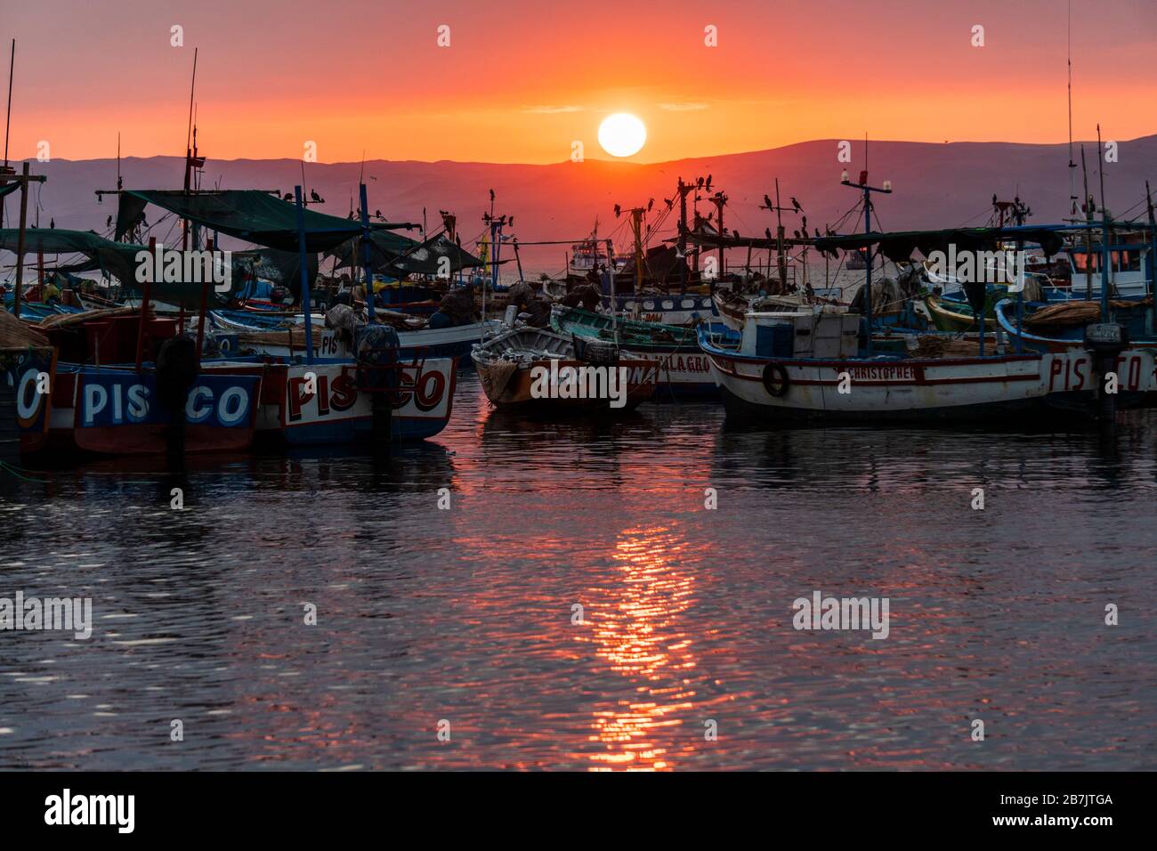 Sunset in the fishing port of Paracas in Peru Stock Photo - Alamy