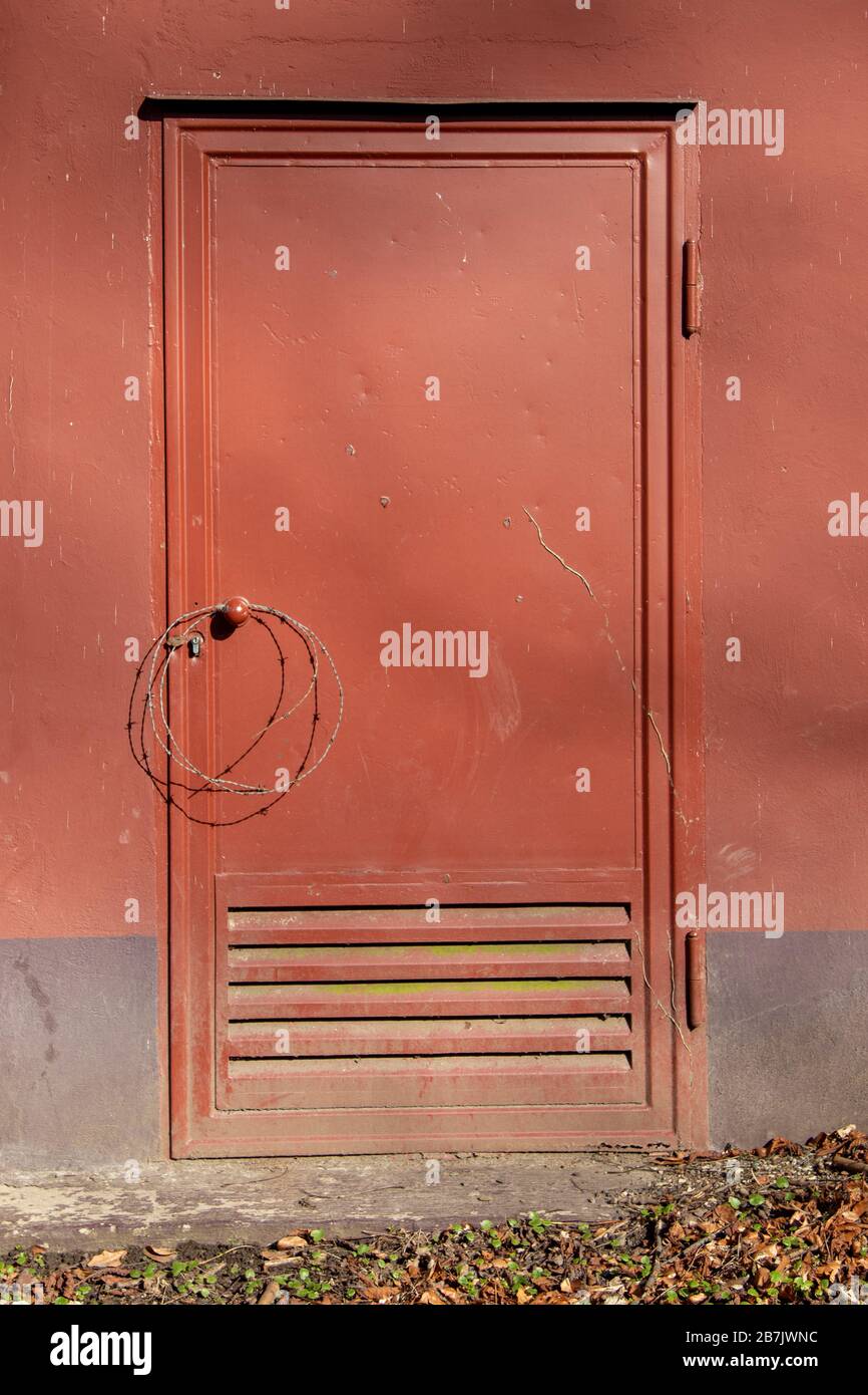 red steel door, red wall, barbed wire on the jack Stock Photo - Alamy