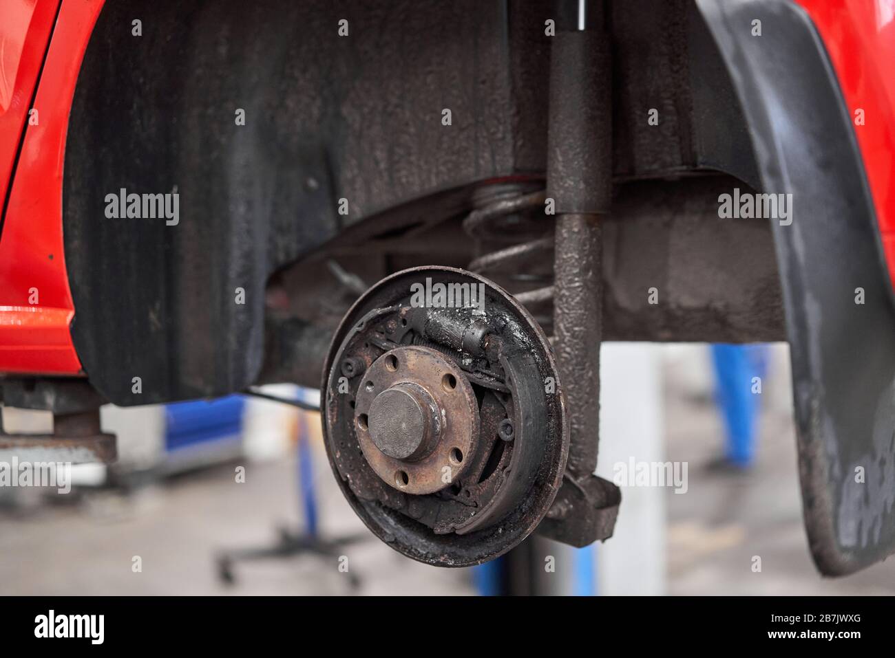 Rusty drum brakes, rear on red car. Change the old to new brake disc on ...