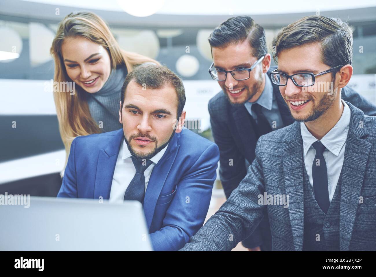 Group of young business people working and communicating while sitting ...