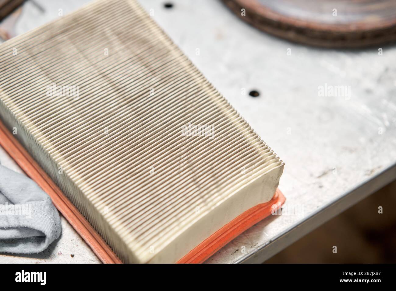 Old dirty automotive engine air filter on metal table of an auto ...