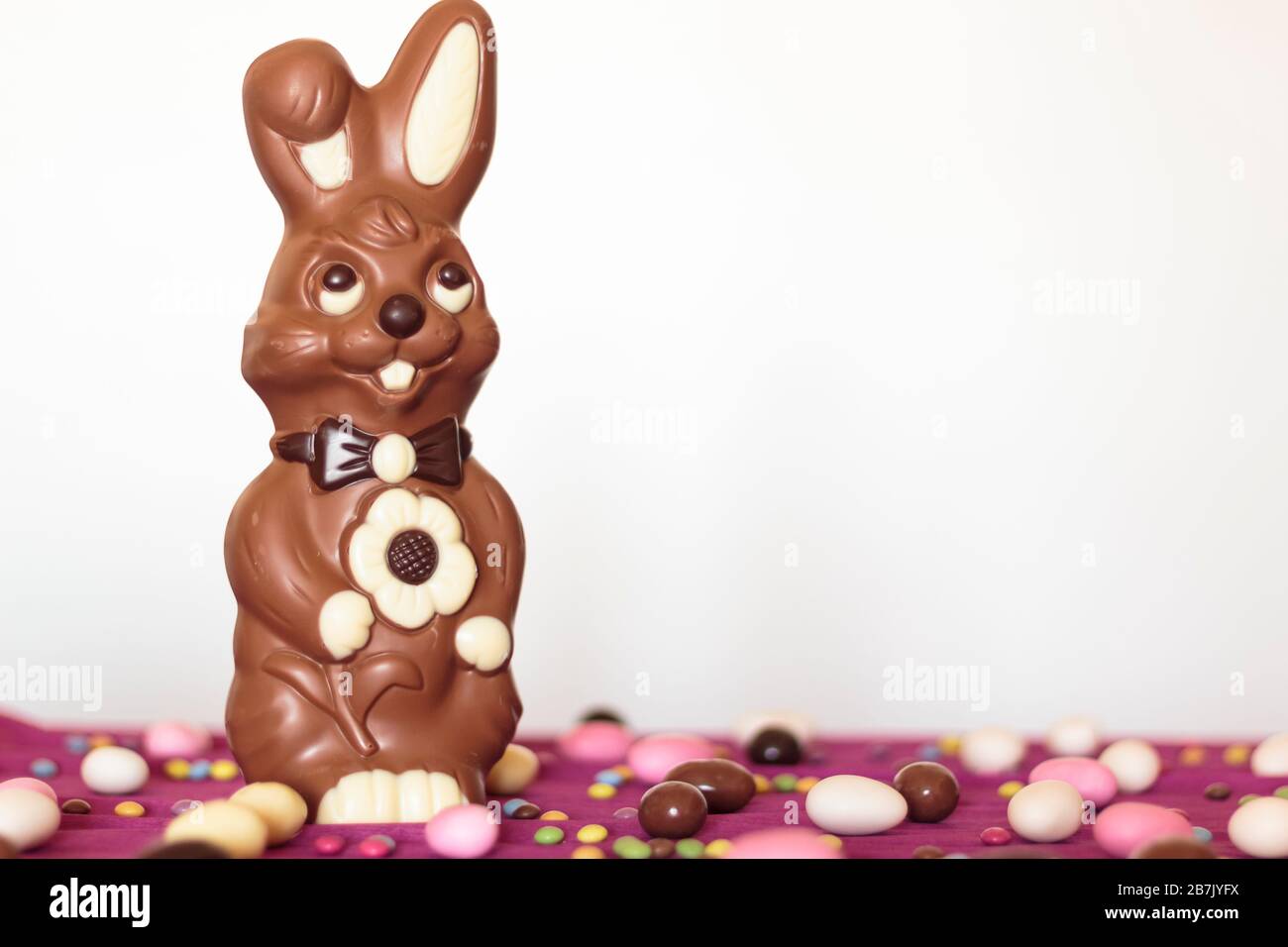 Sweet chocolate easter bunny and colorful easter almonds on white ...