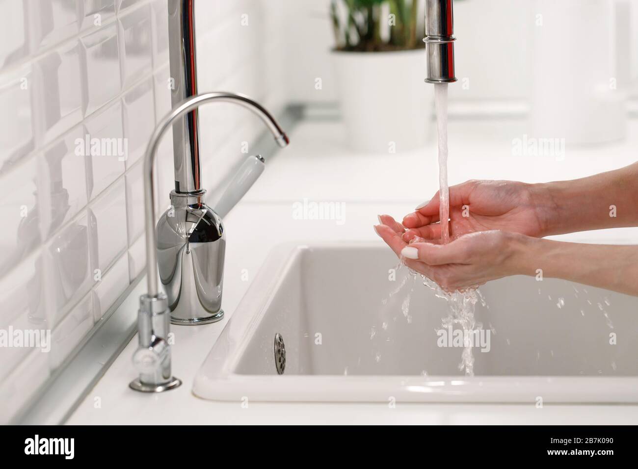 Woman washing and cleaning her hands under flowing tap water in the ...