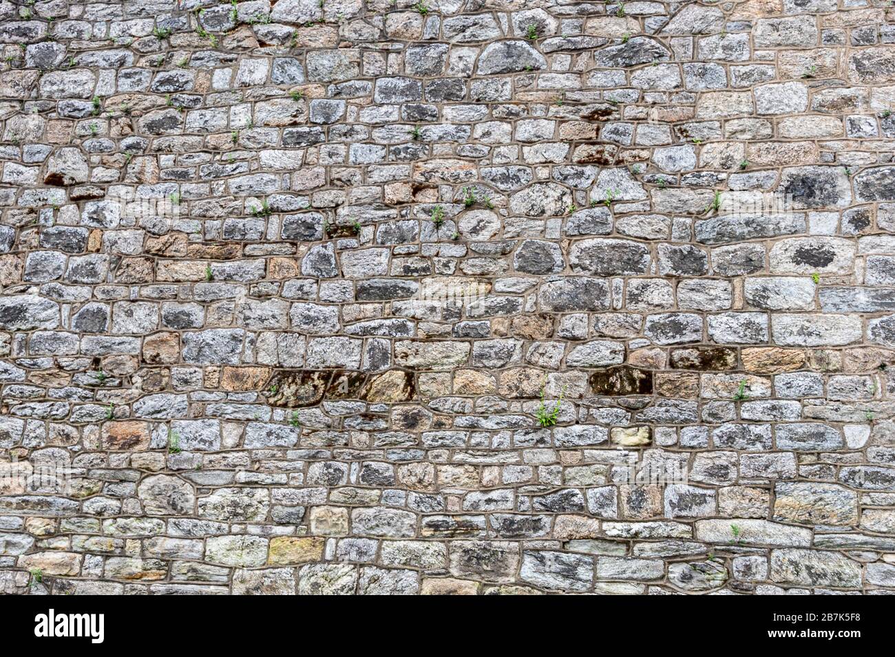 Flat stone wall background, made from irregular sized stone blocks at ...