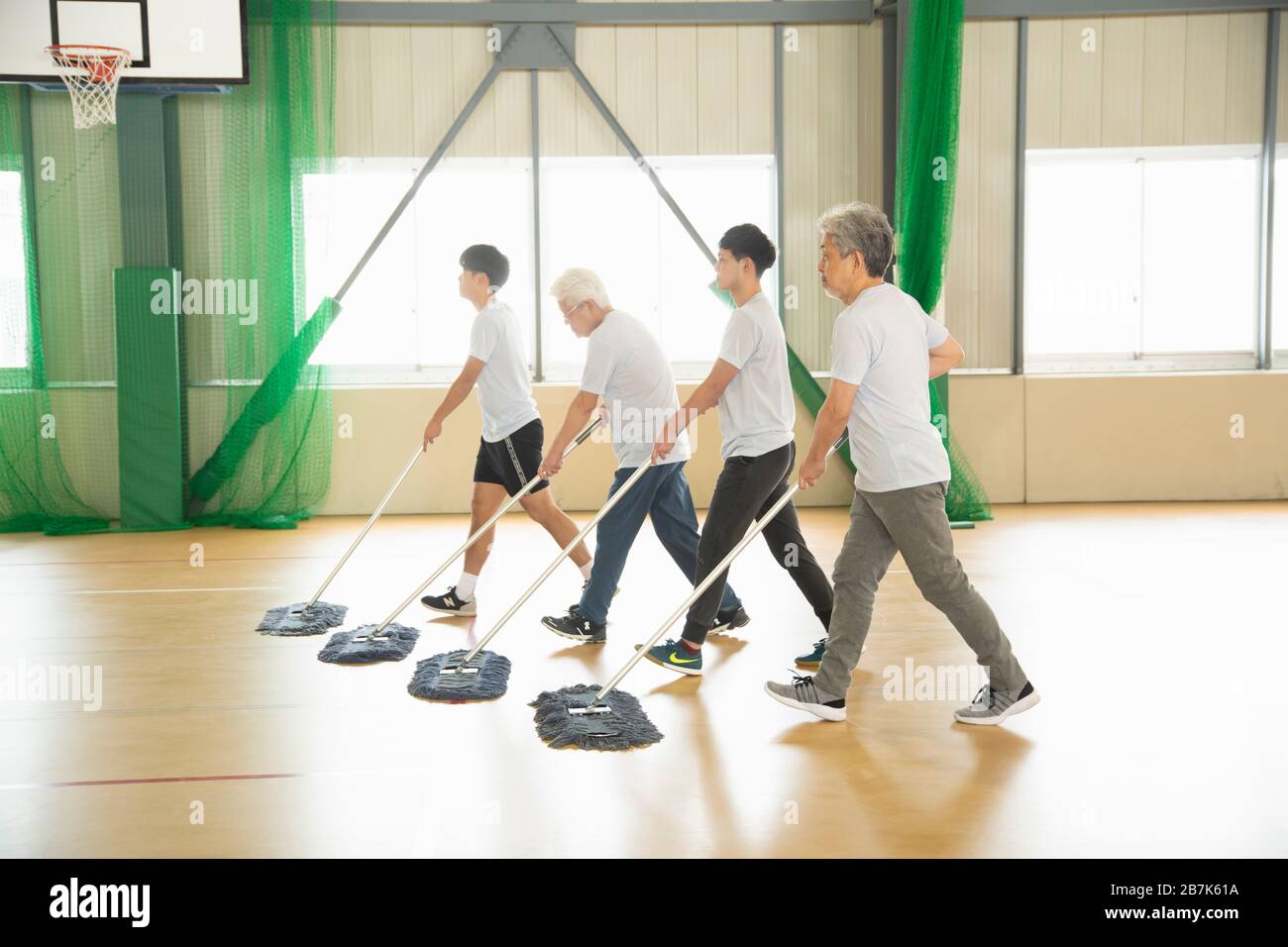 Senior and young people mopping in row Stock Photo - Alamy