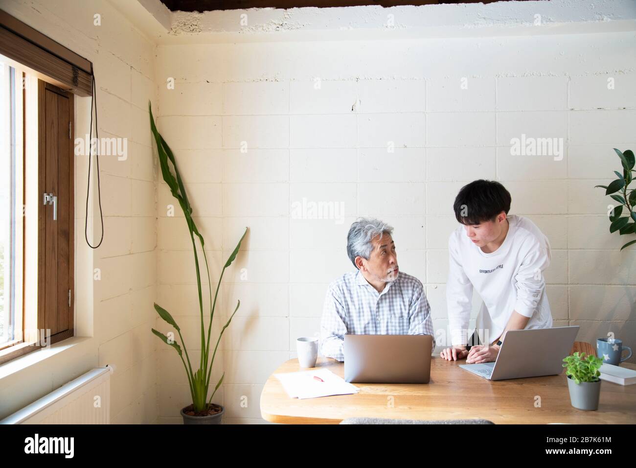 Senior instructed PC by young man Stock Photo - Alamy