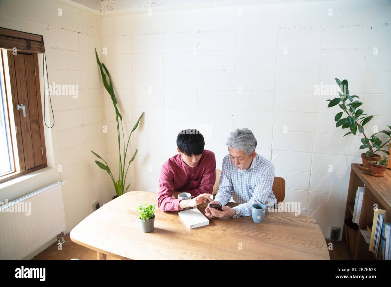 Senior instructed smartphone by young man Stock Photo - Alamy