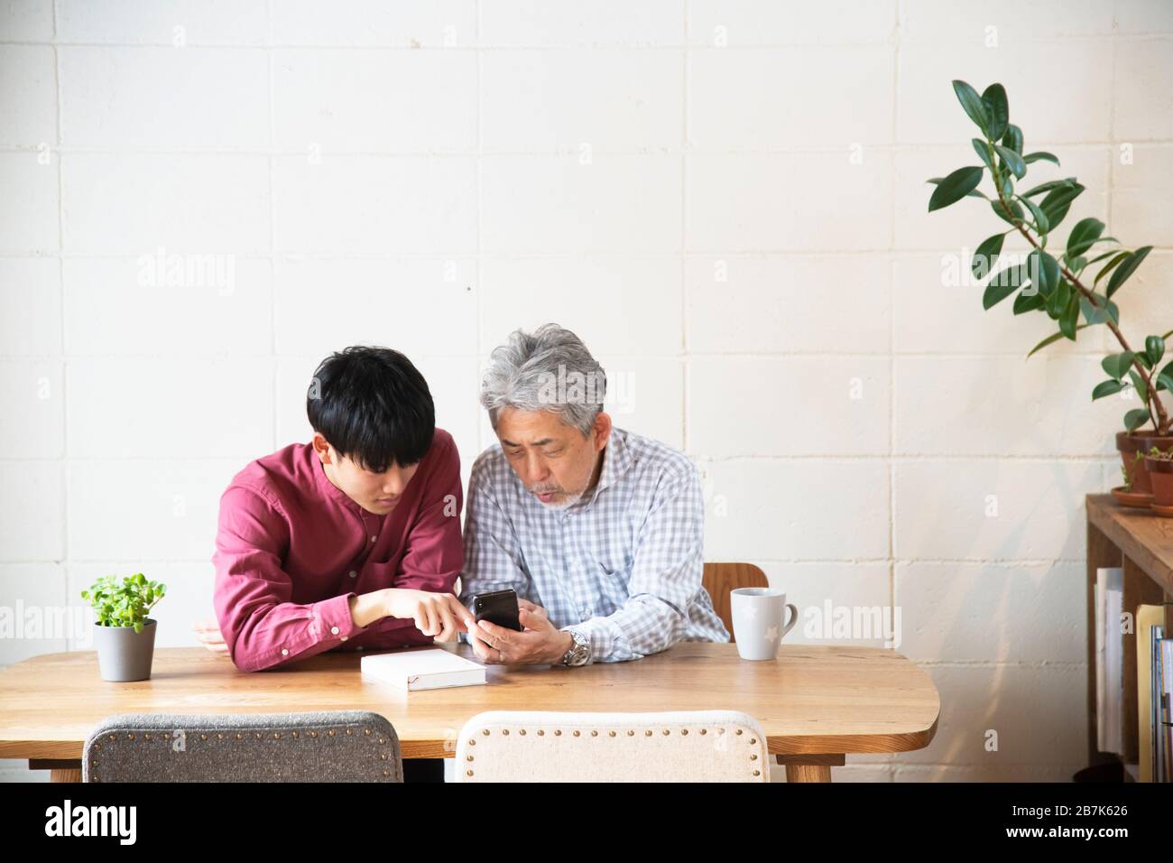 Senior instructed smartphone by young man Stock Photo - Alamy