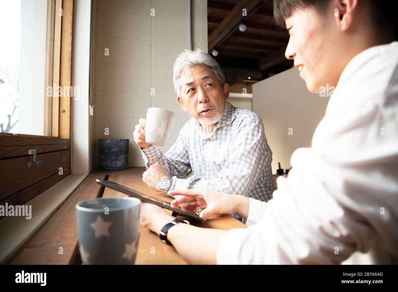 Senior and young people talking with smile by window Stock Photo - Alamy