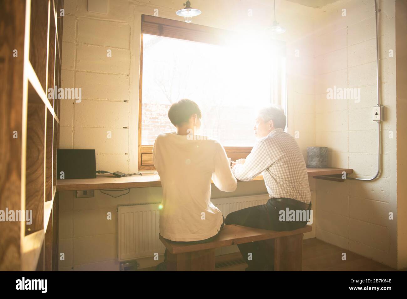 Senior and young people talking with smile by window Stock Photo - Alamy