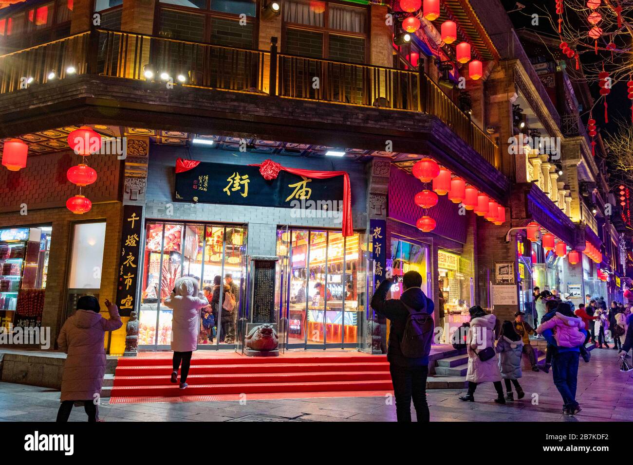 Pedestrians walk in Qianmen Walking Street where all lights turn on to ...