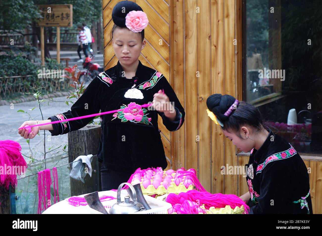 --File--Two persons dressed in Miao style clothes do handcraft at the ...