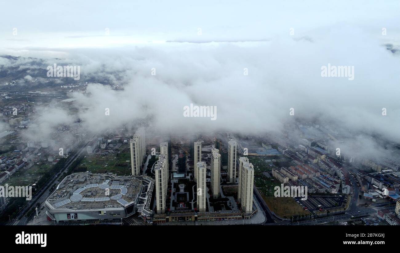 An aerial view of high-rises in urban area standing in fog after rain ...