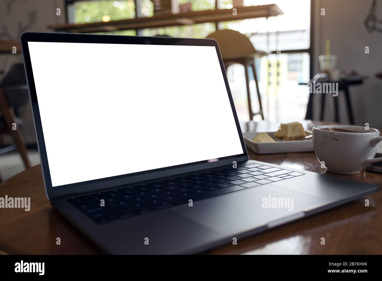 Mockup image of laptop with blank white desktop screen with coffee cup ...