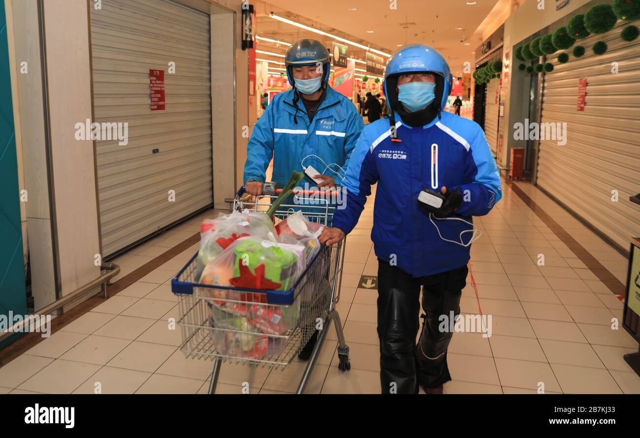 Delivery persons of Eleme.com carry deliveries at a supermarket in ...