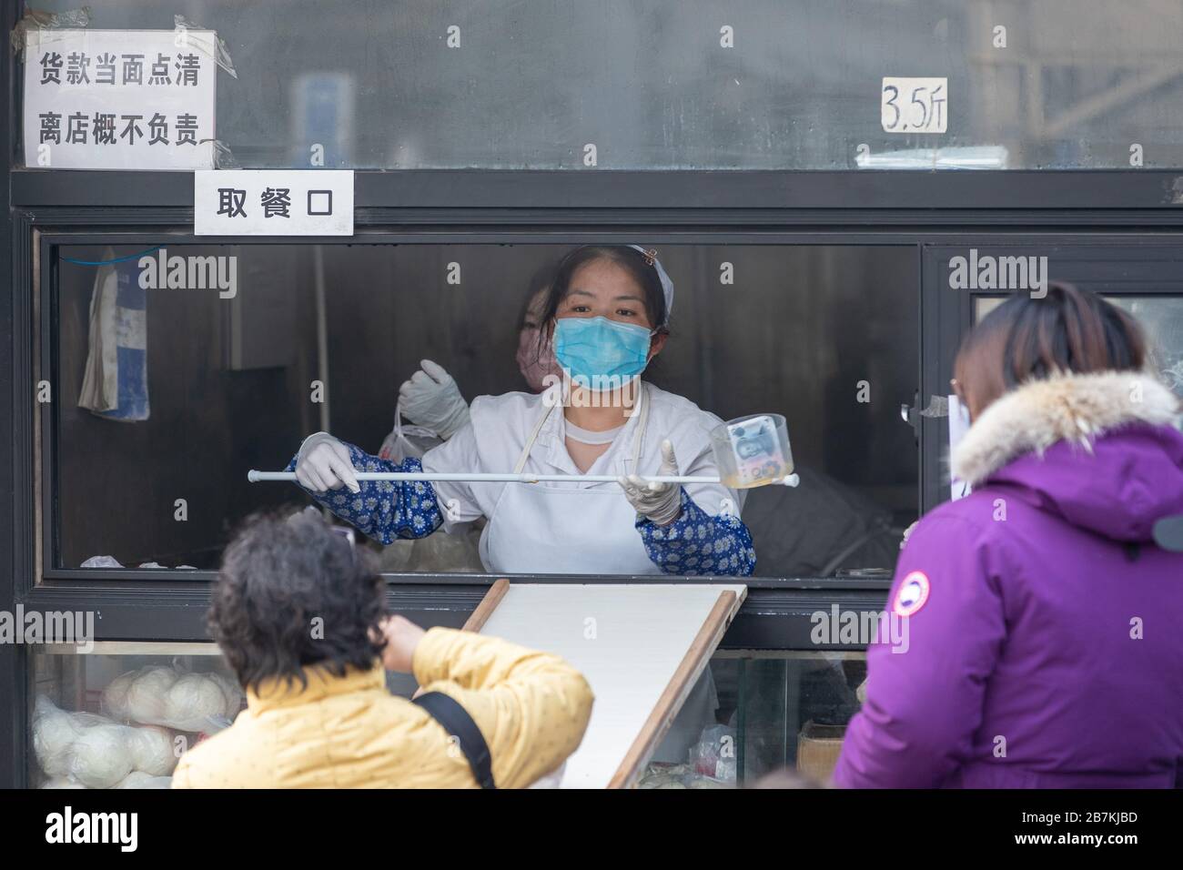 A staff of a steamed bun shop delivers buns to customers using a wooden ...