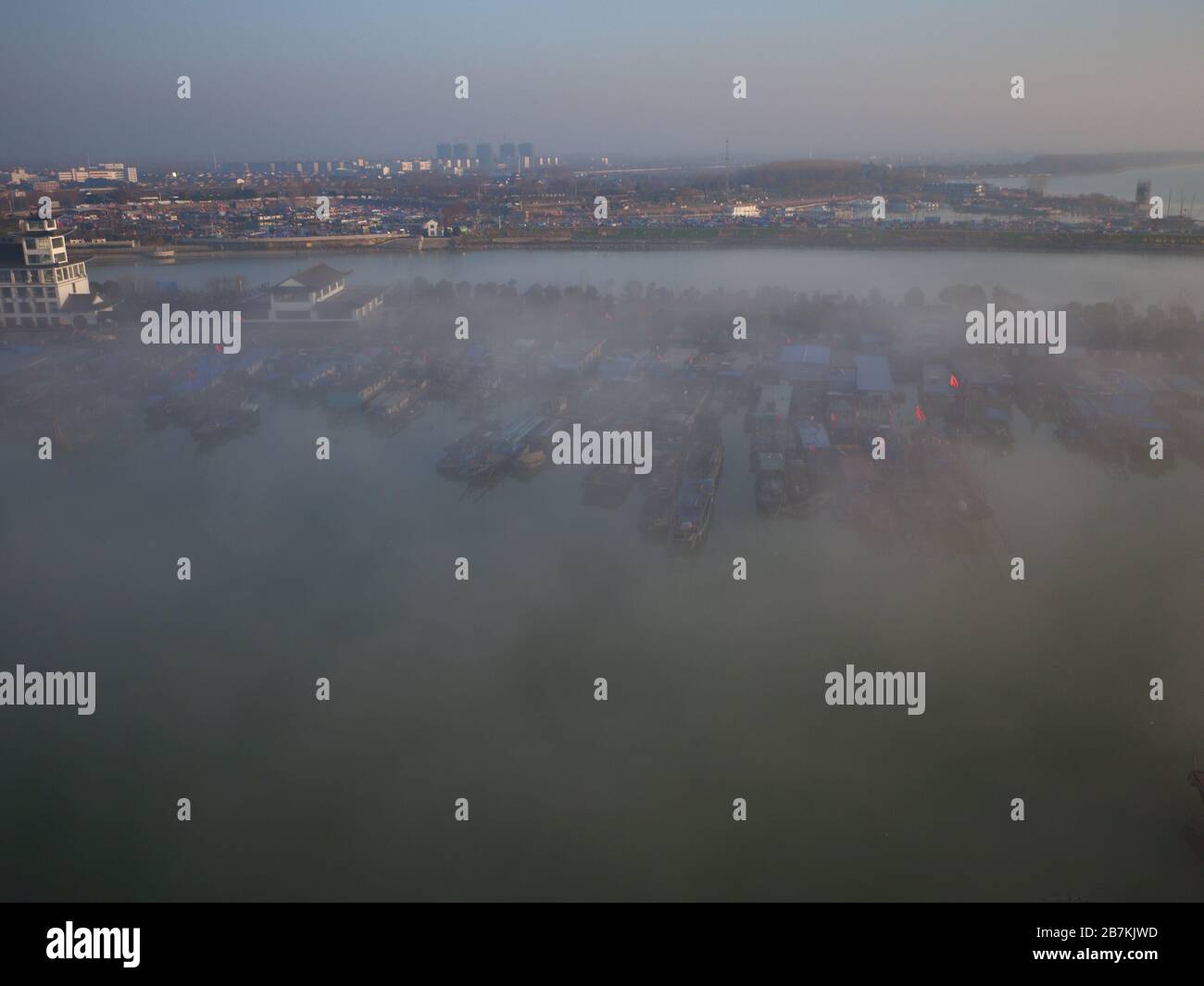 An aerial view of boats and vessels harboring at a pier and covered in ...