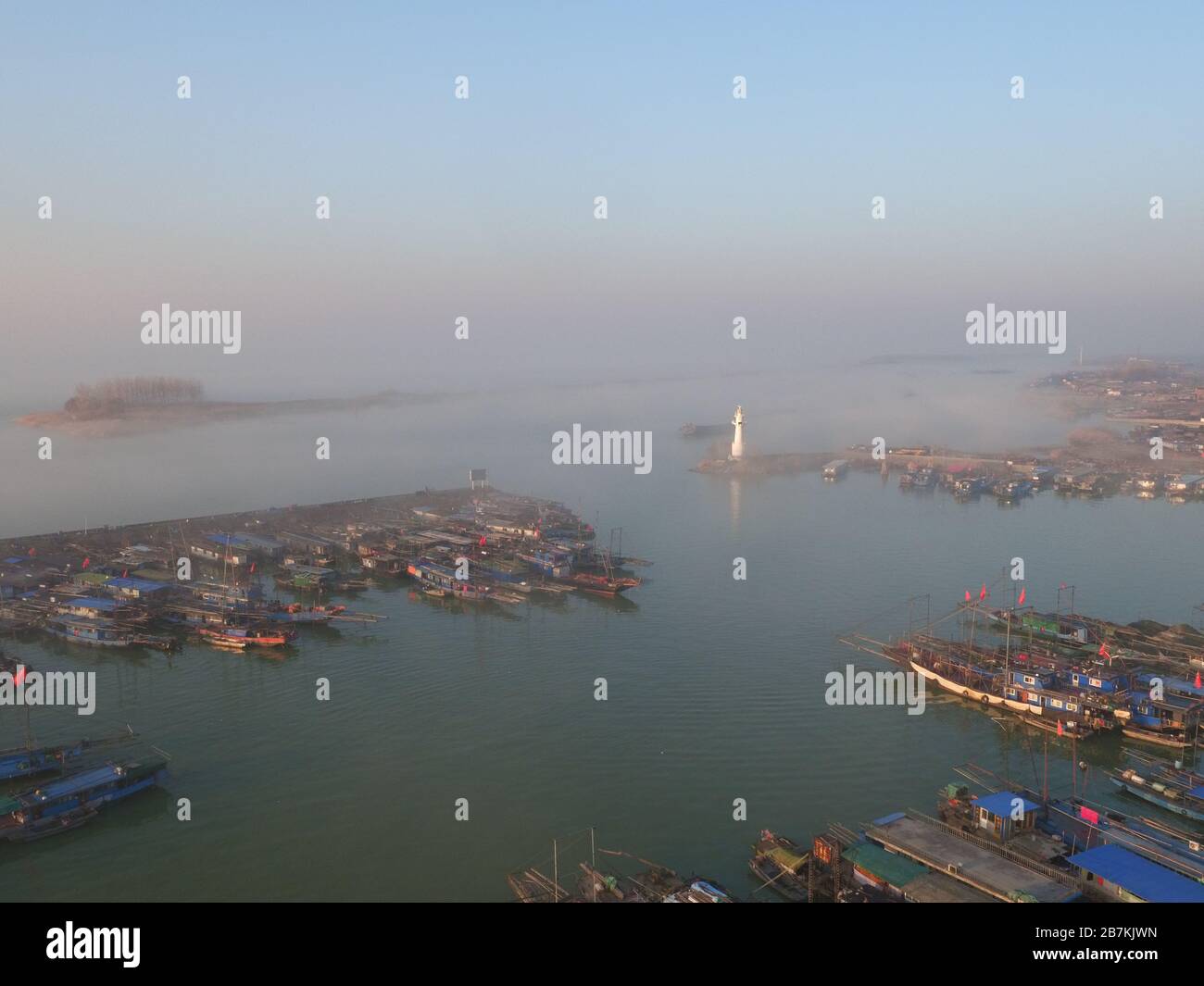 An aerial view of boats and vessels harboring at a pier and covered in ...