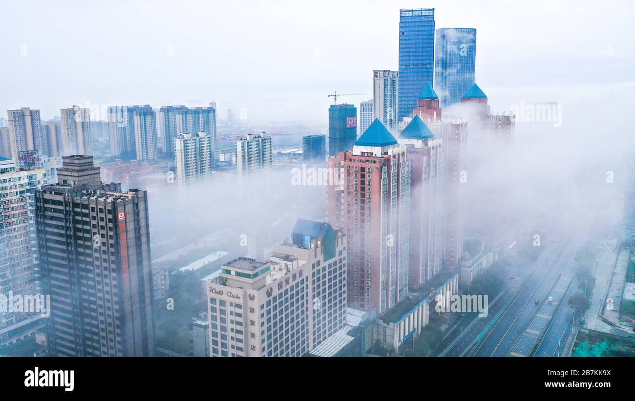 An aerial view of the whole city being covered by heavy fog, resembling ...