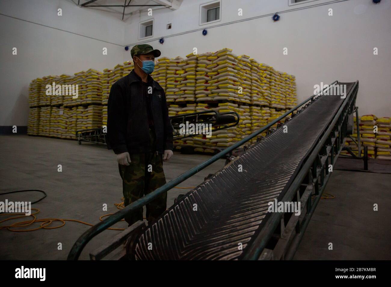 Labors work at a warehouse storing rice after long Spring Festival ...