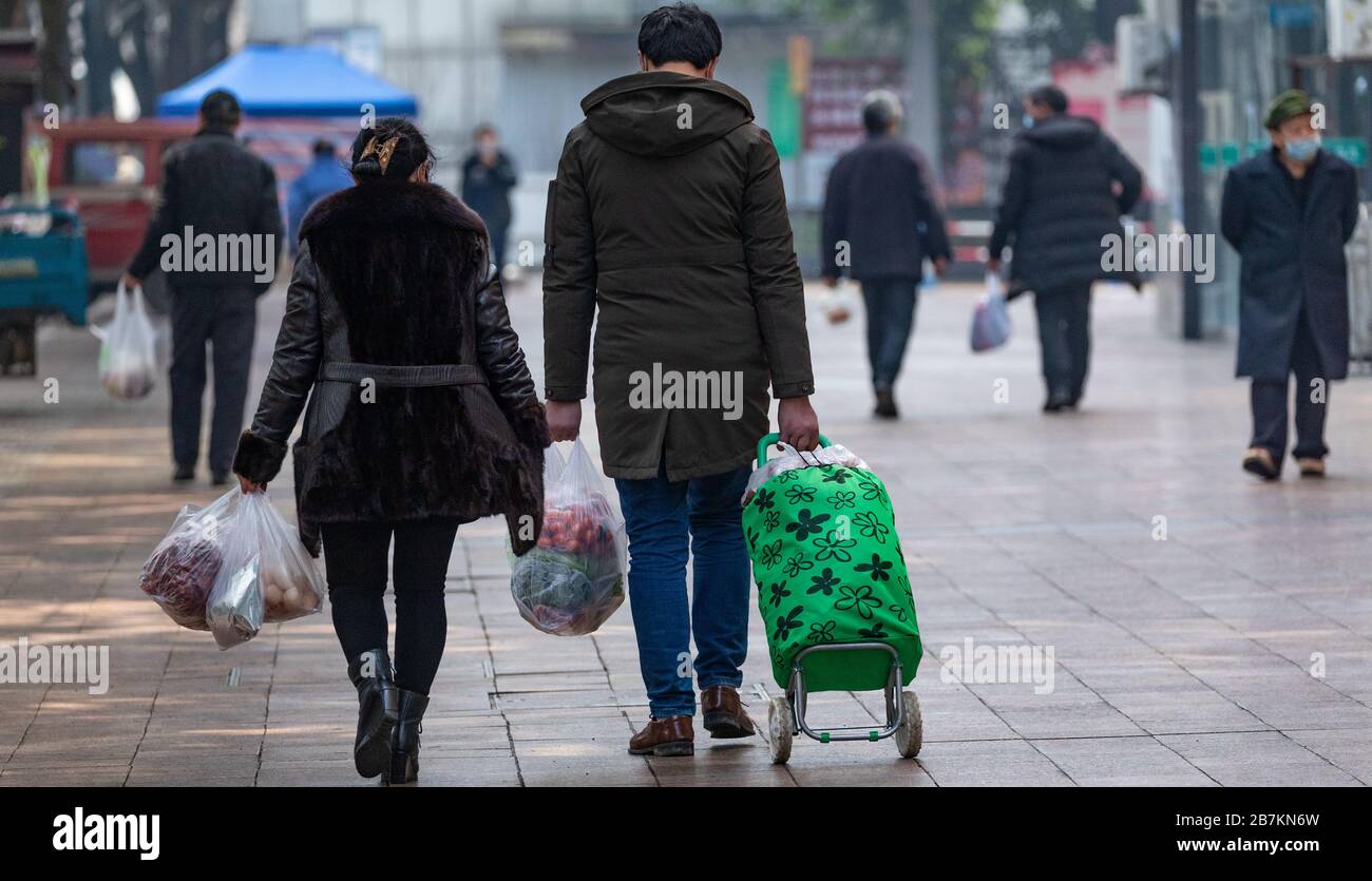 People carry food walking on a street in Nanchuan district in Chongqing ...