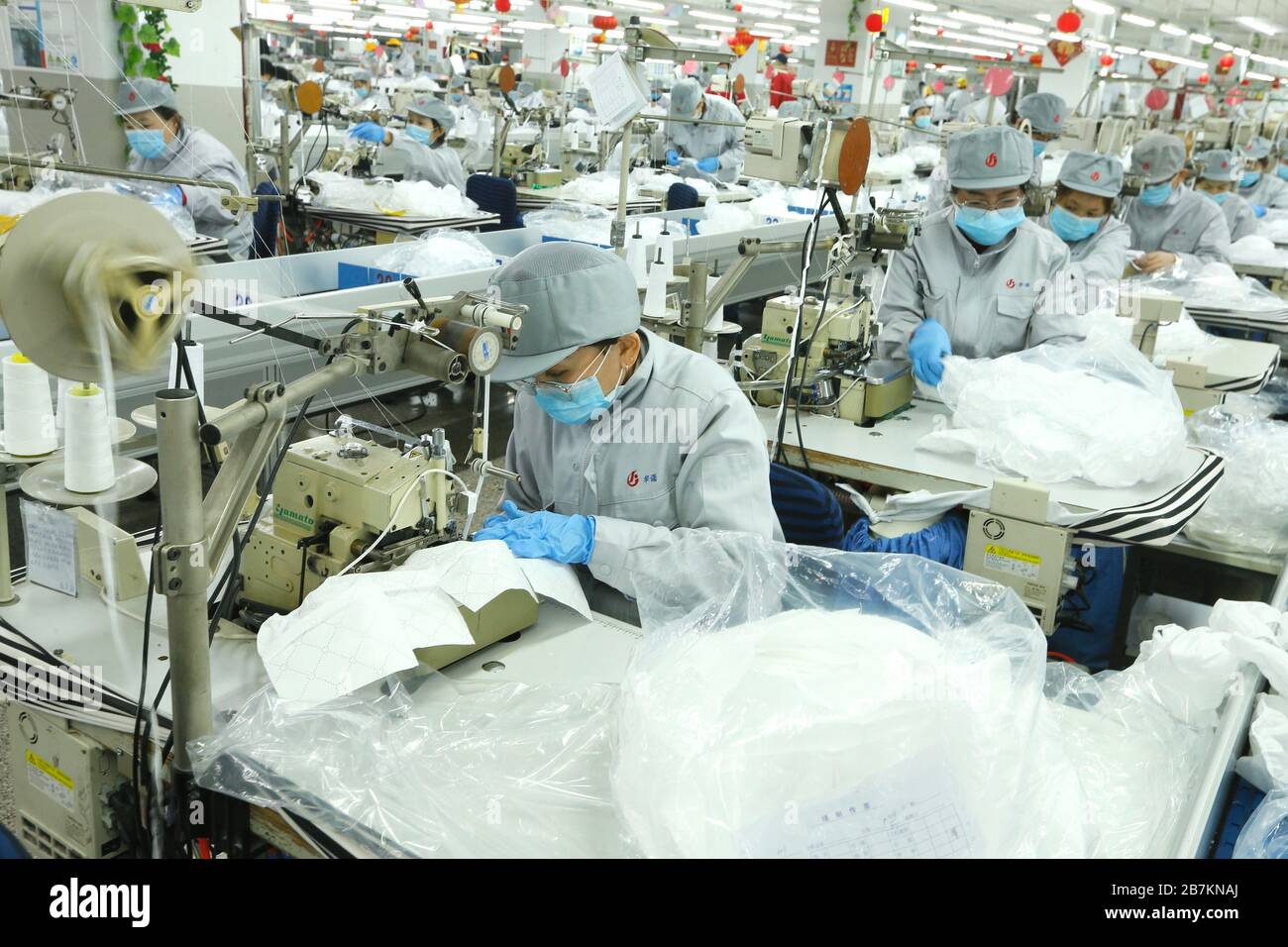 Staff of a spinning mill are busy at producing masks to meet the ...