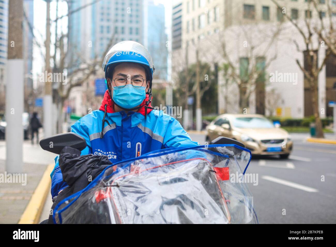 Delivery man Liu Along drives a scooter on a street in Shanghai, China ...