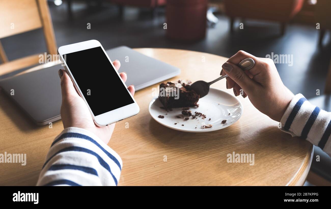 Mockup image of a woman holding white mobile phone with blank black ...