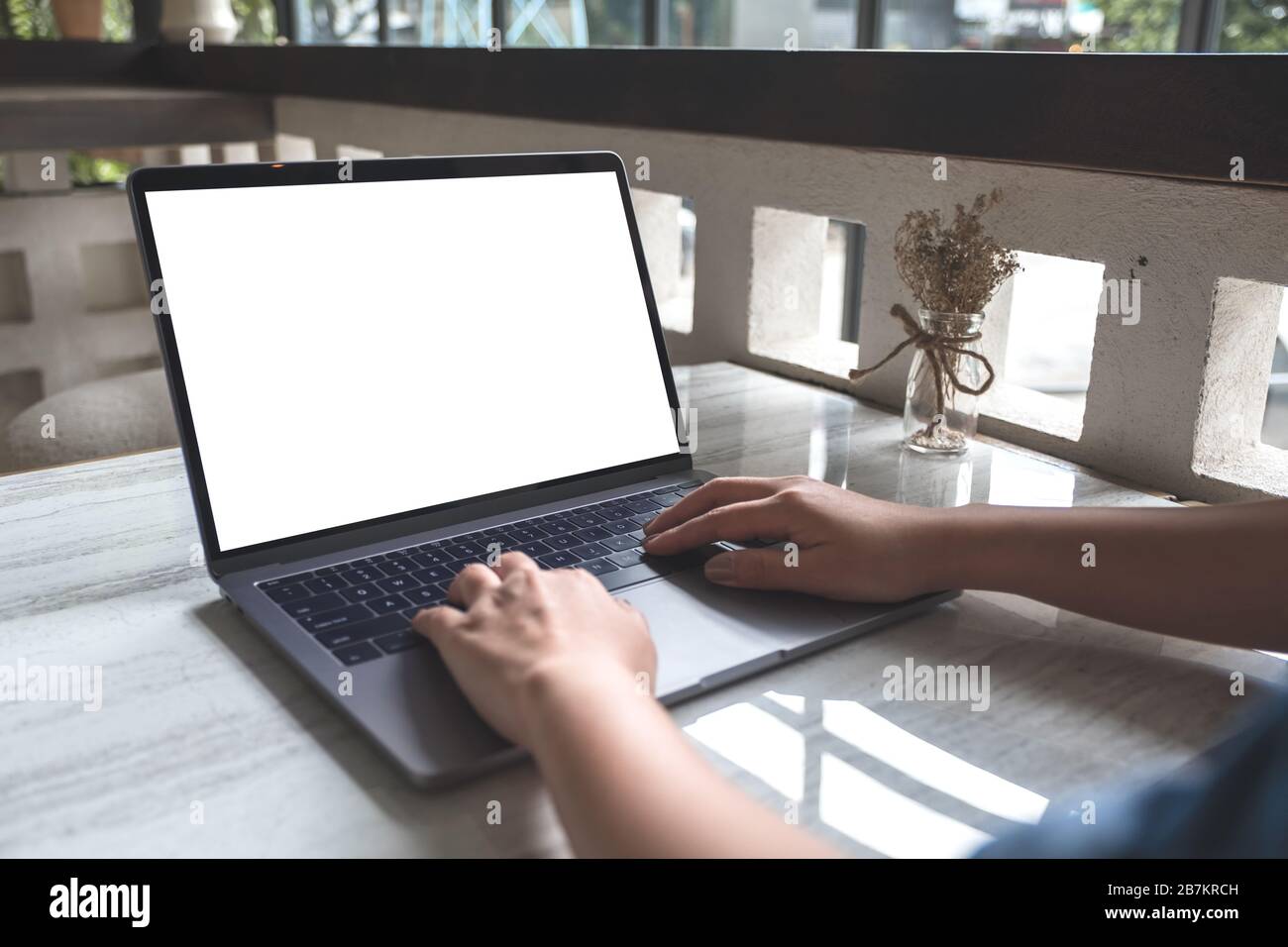 Mockup image of a woman using and typing on laptop with blank white ...