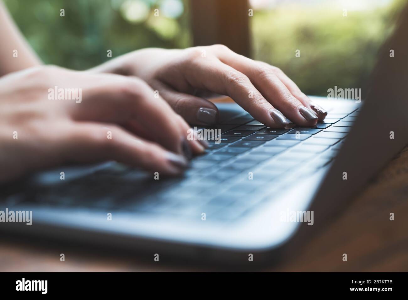 Closeup image of woman's hands working and typing on laptop keyboard on ...