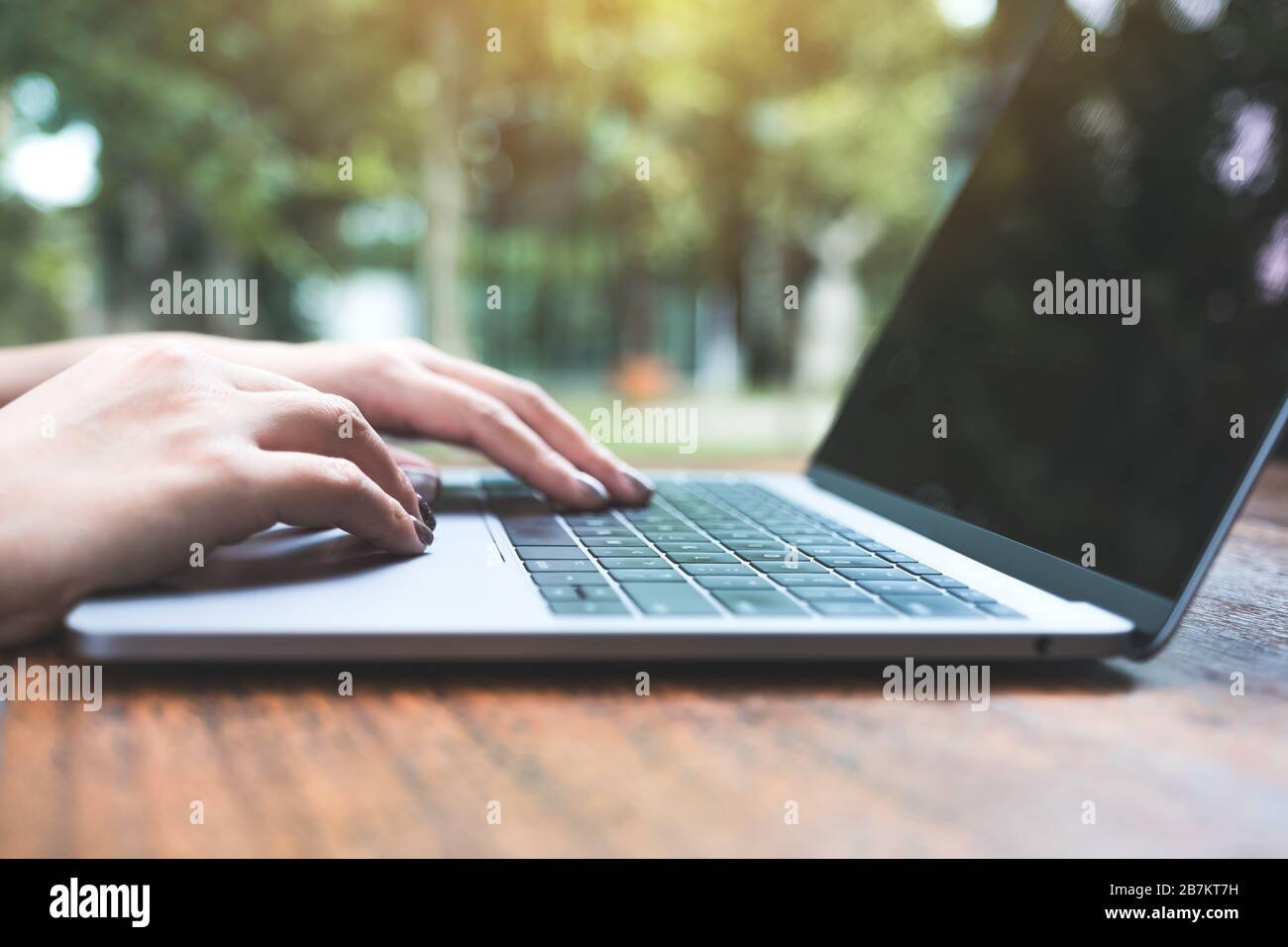 Closeup image of woman's hands working and typing on laptop keyboard on ...