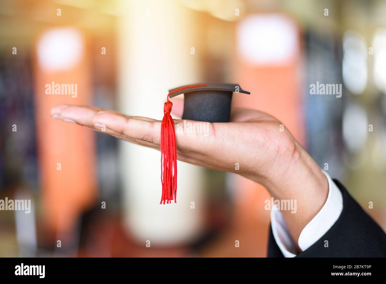 Business man or student with graduation cap on hand in day graduation ...