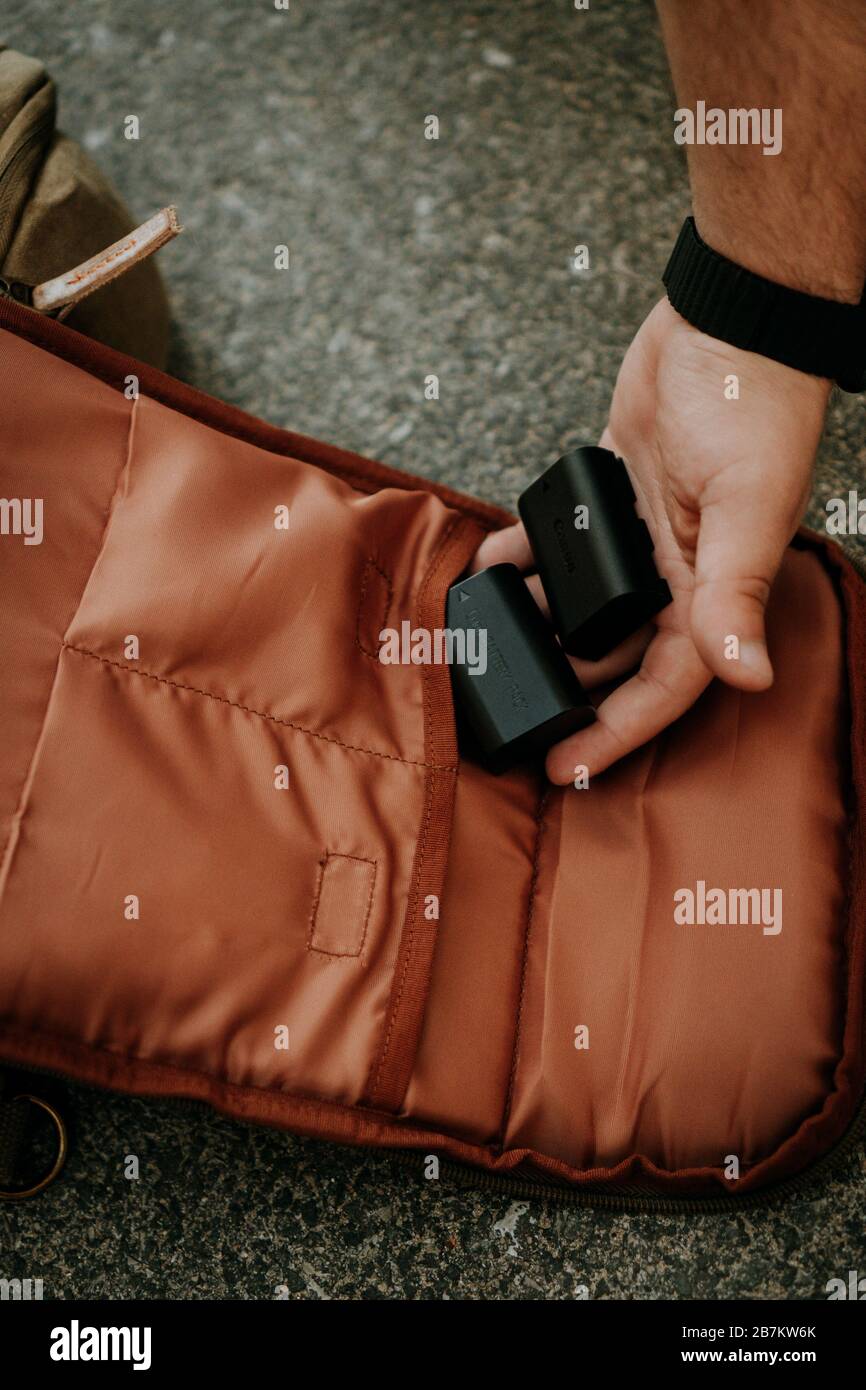 Photographer pulling out spare batteries from the inner pocket of a ...