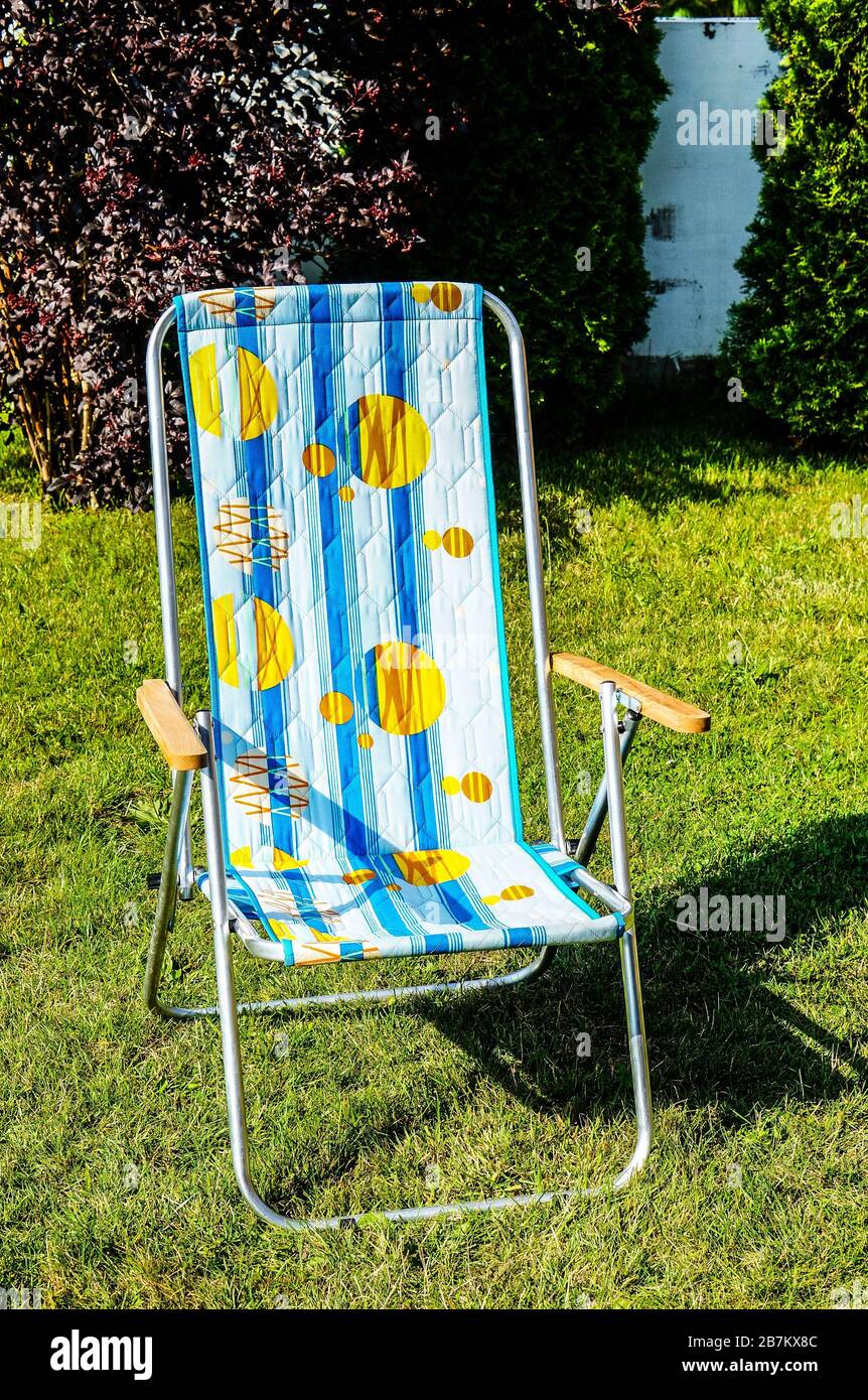 Vertical blue and white striped sun chair on the green grass Stock ...