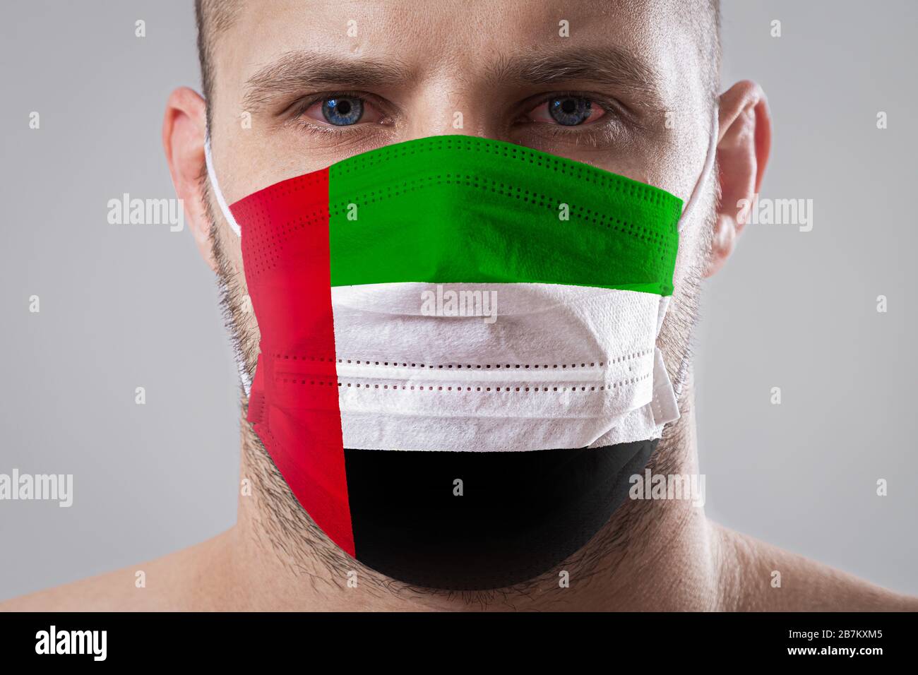 Young man with sore eyes in a medical mask painted in the colors of the ...