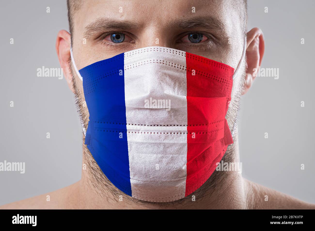 Young man with sore eyes in a medical mask painted in the colors of the ...