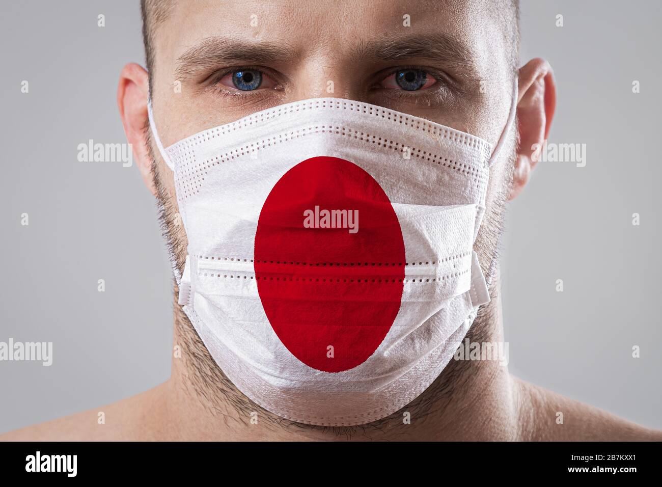 Young man with sore eyes in a medical mask painted in the colors of the ...