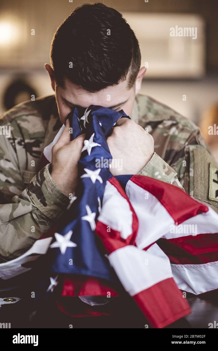 Vertical shot of an American soldier mourning and praying with the ...