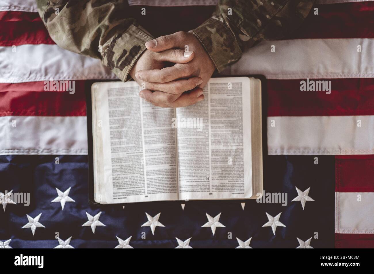 American soldier mourning and praying with the American flag and the ...