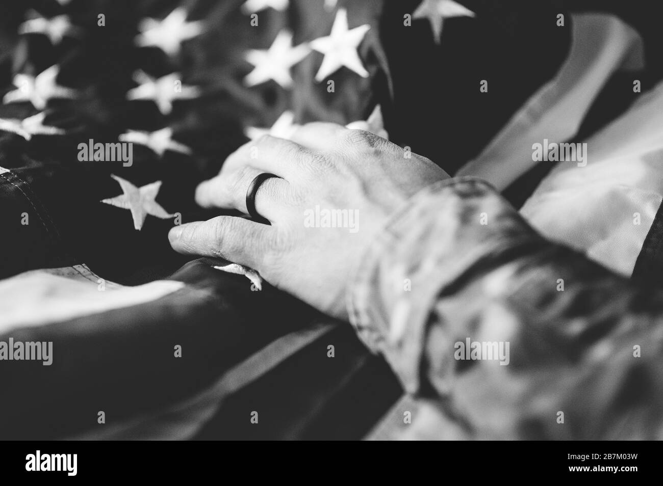 Greyscale shot of an American soldier mourning and praying with the ...