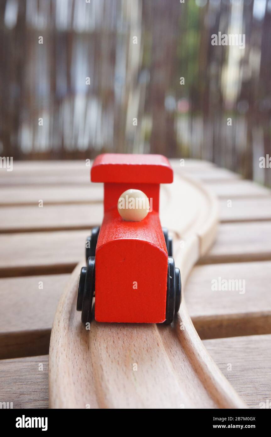 Wooden red toy train on wooden tracks Stock Photo - Alamy