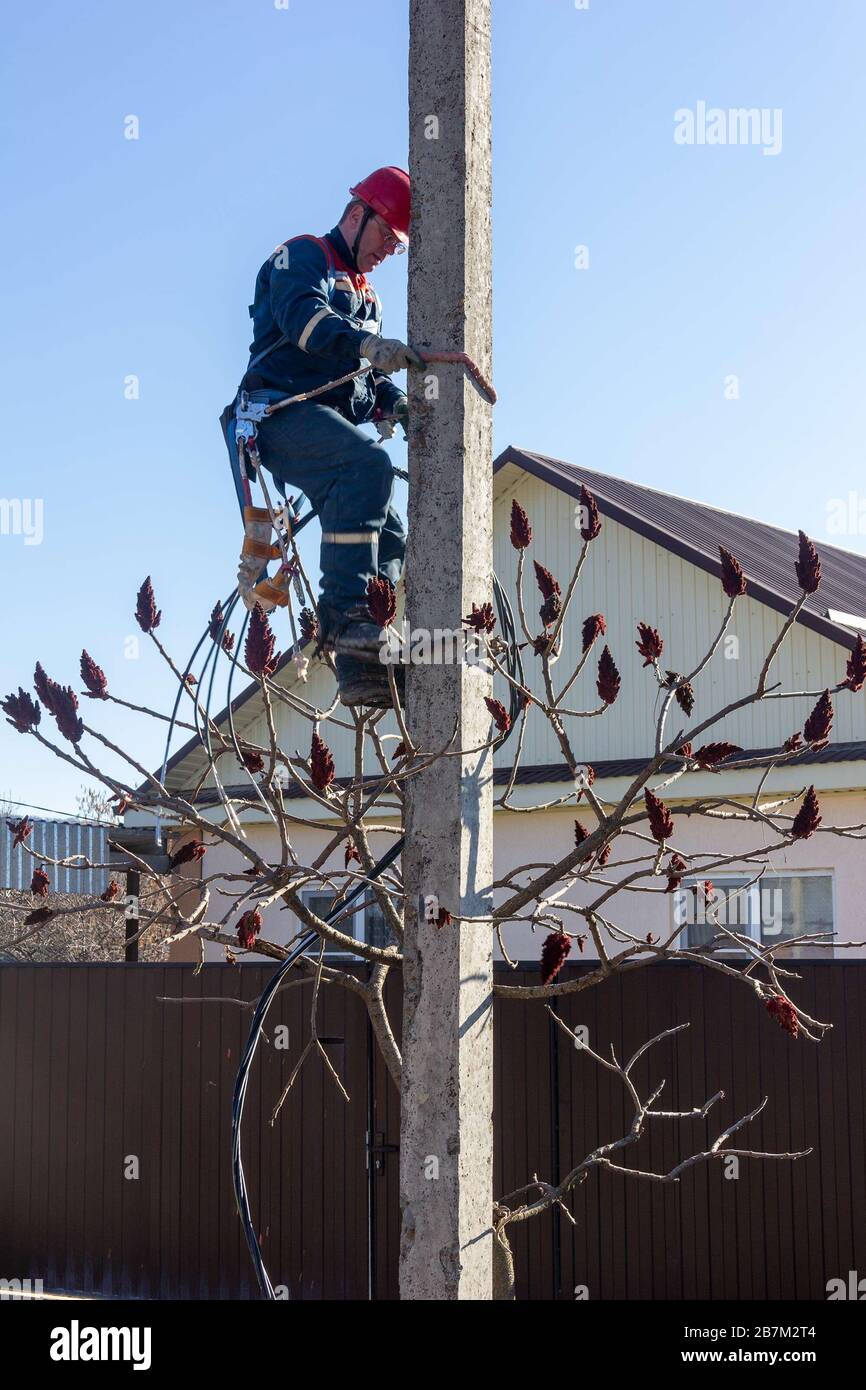 Krasnodar, Russia - March 2, 2020: a male electrician climbs up a ...