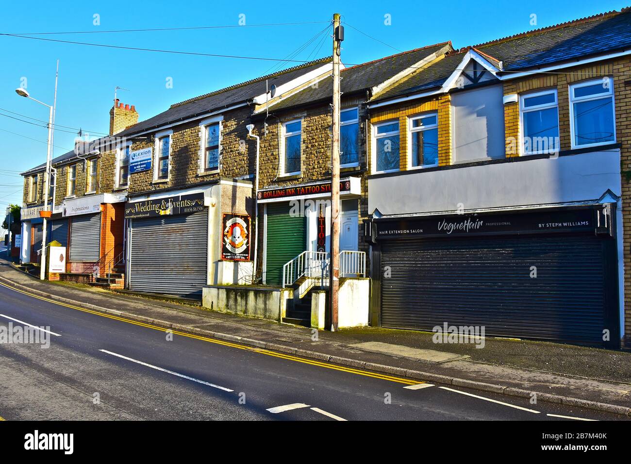 A row of traditional small shop units, some with flats over, on the ...