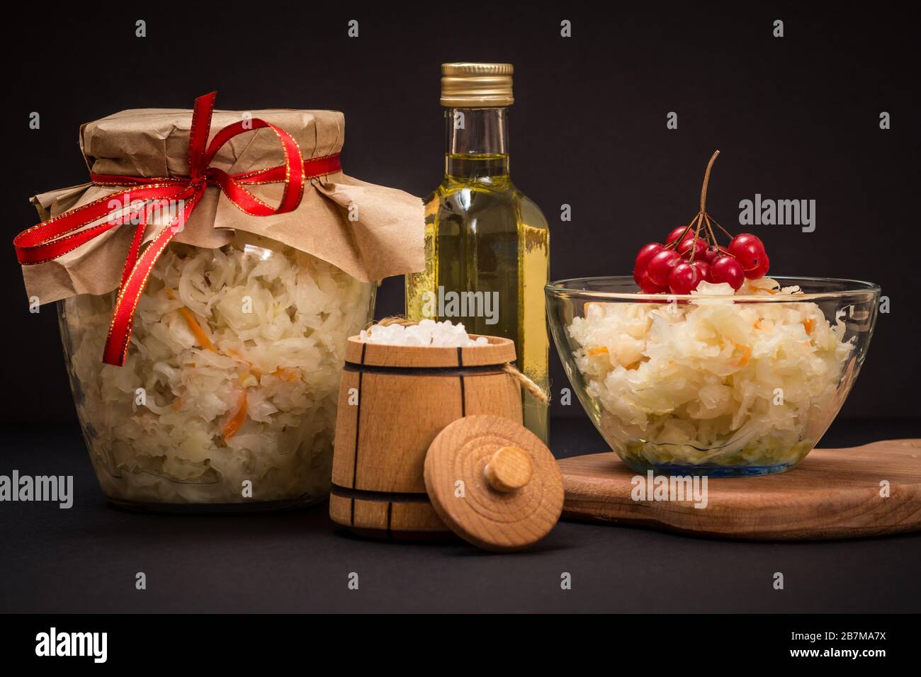 Homemade fermented cabbage in glass bowl and jar, small wooden barrel ...