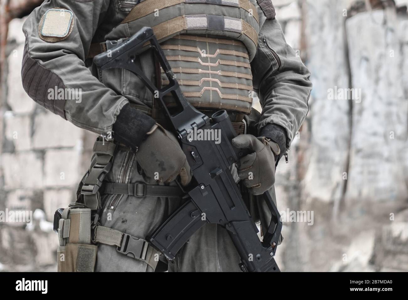 A military man with a machine gun is on duty. Close up Stock Photo - Alamy